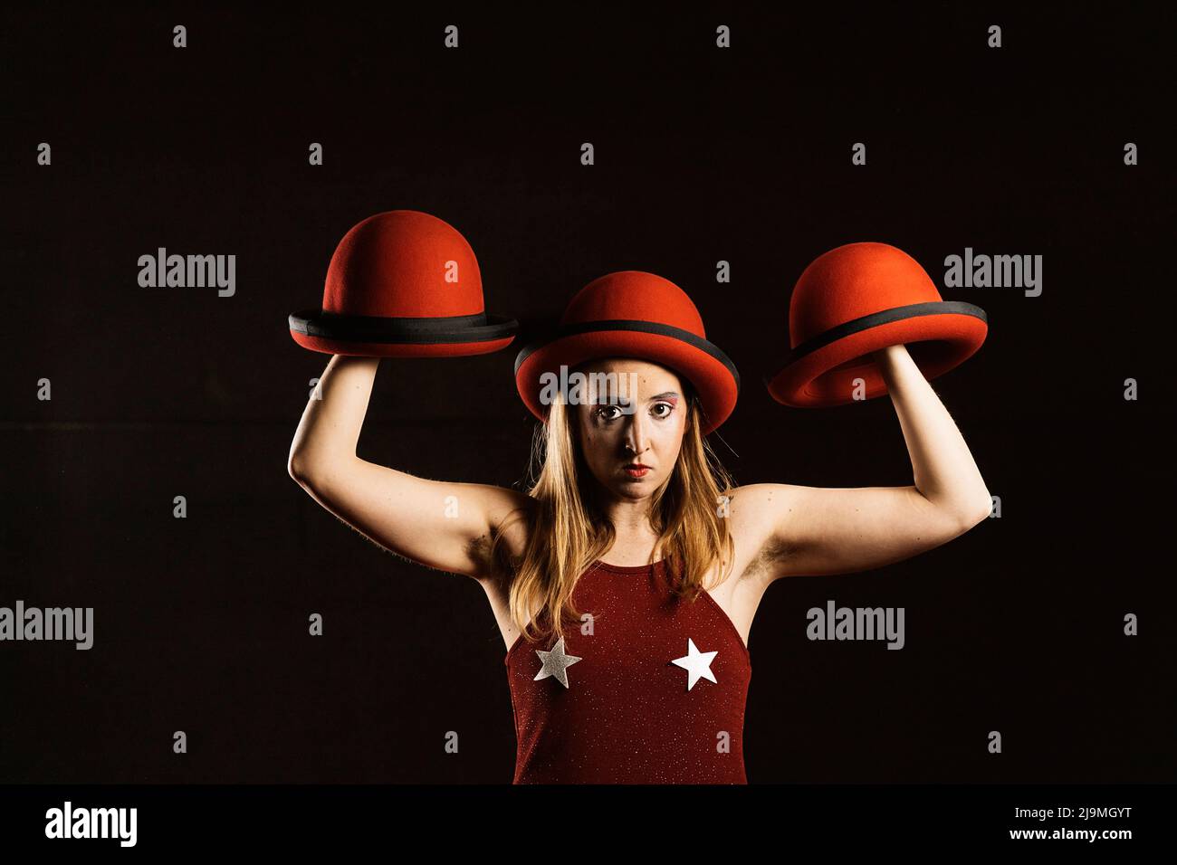 Serious young female circus artist with long blond hair in dress ...
