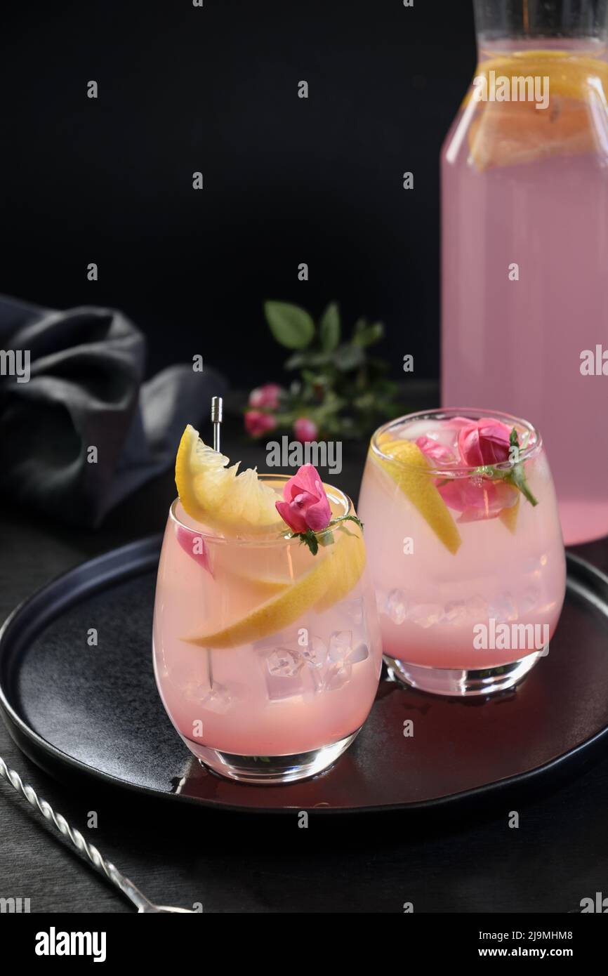 Alcoholic cocktails with pink rose gin and lemon on black background ...