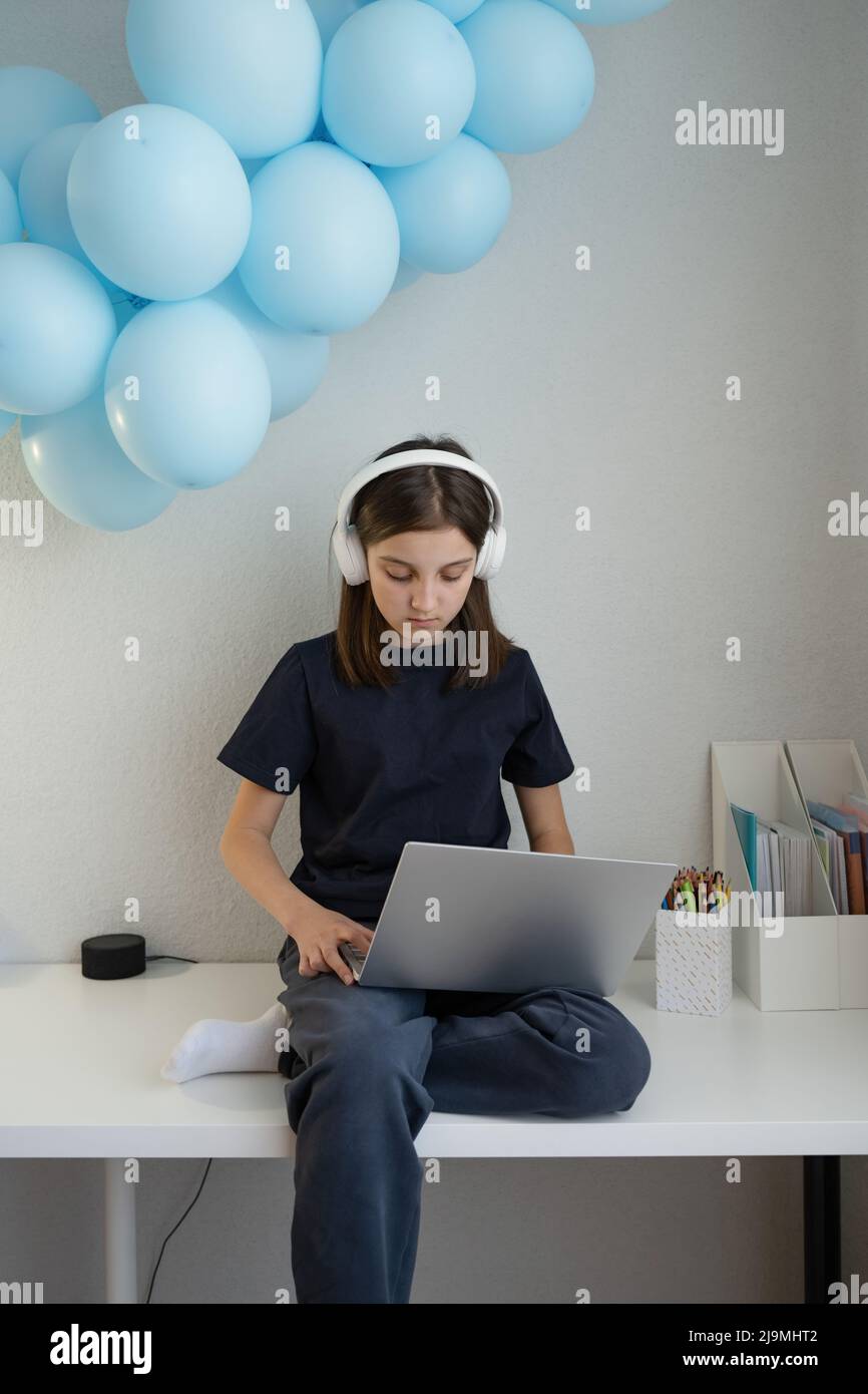 From above serious teenage girl in casual clothes and headphones ...