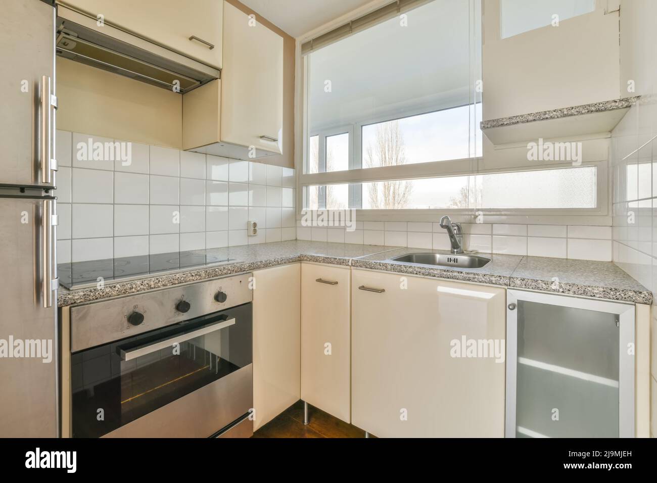 Counter with cupboards and sink placed in light kitchen in apartment ...