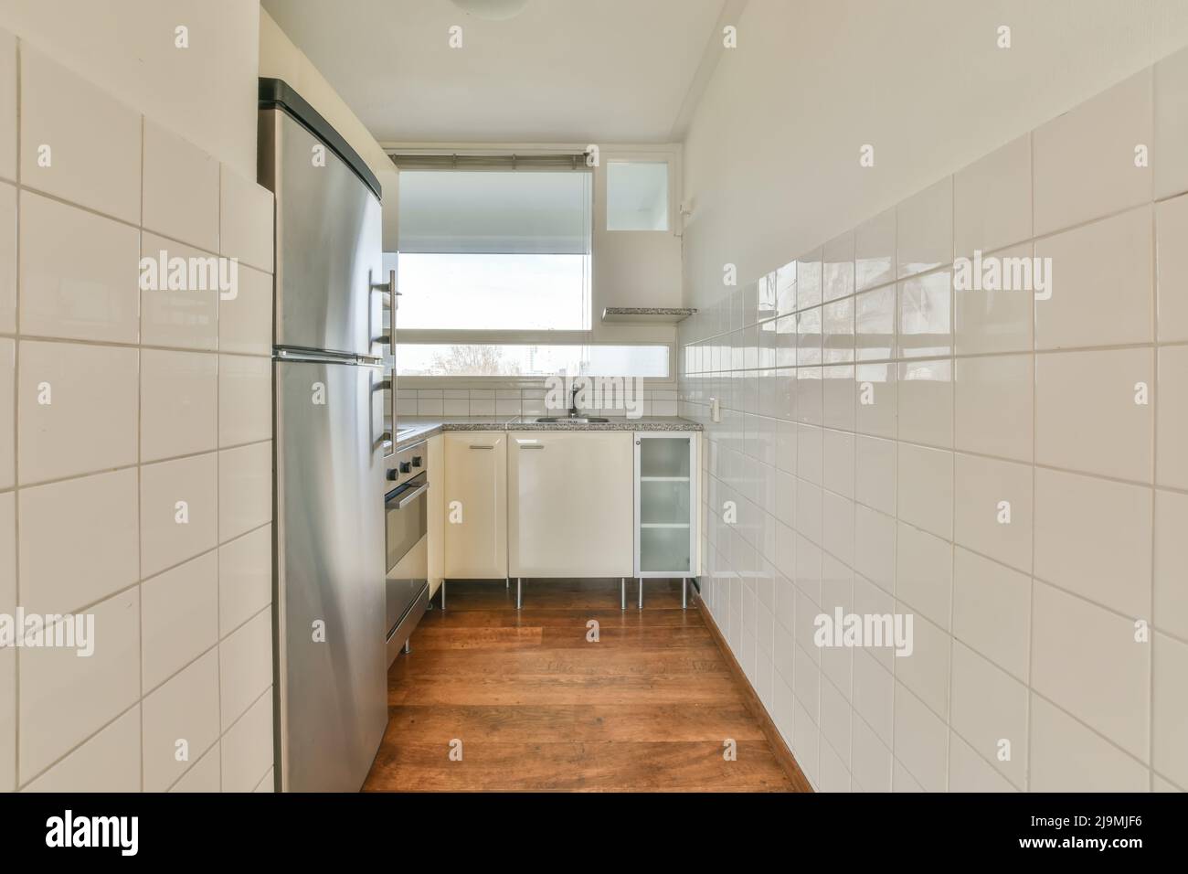 Counter with cupboards and sink placed in light kitchen in apartment ...
