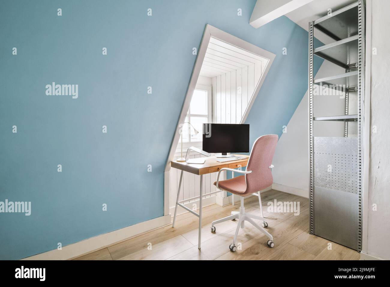 Desk with computer and chair located in light workplace in daytime in ...