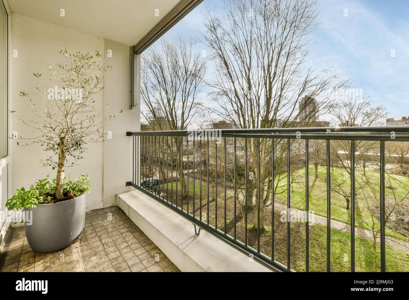 Balcony with metal fence on residential building overlooking park and ...
