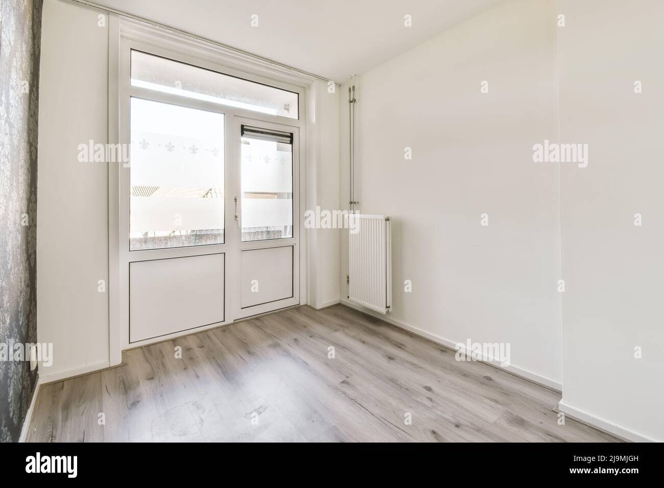 Interior of spacious empty room with laminated floor and wallpaper with ...