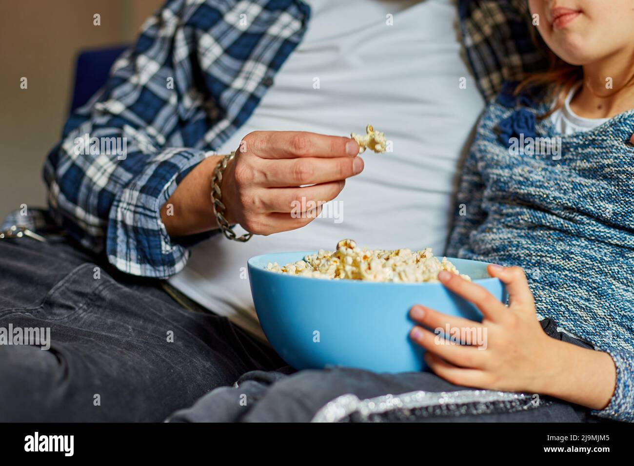 Father and daughter eat popcorn and watch TV film, Dad and child girl ...