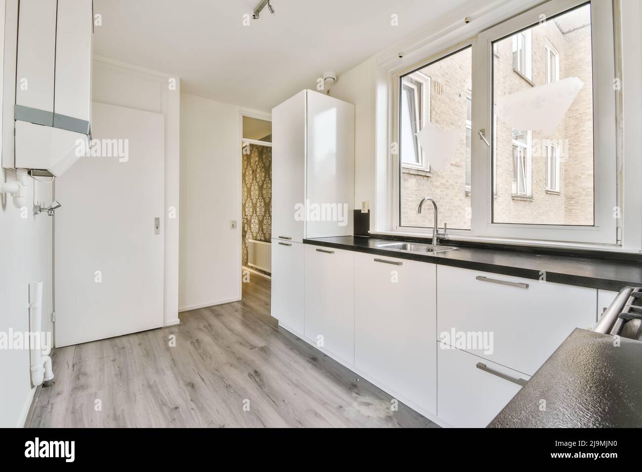 Counter with white cupboards and sink placed in light kitchen in ...