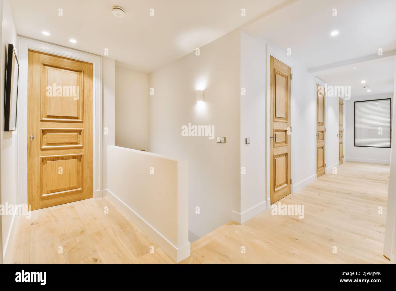 Interior of light hallway with many wooden doors and steps leading down ...
