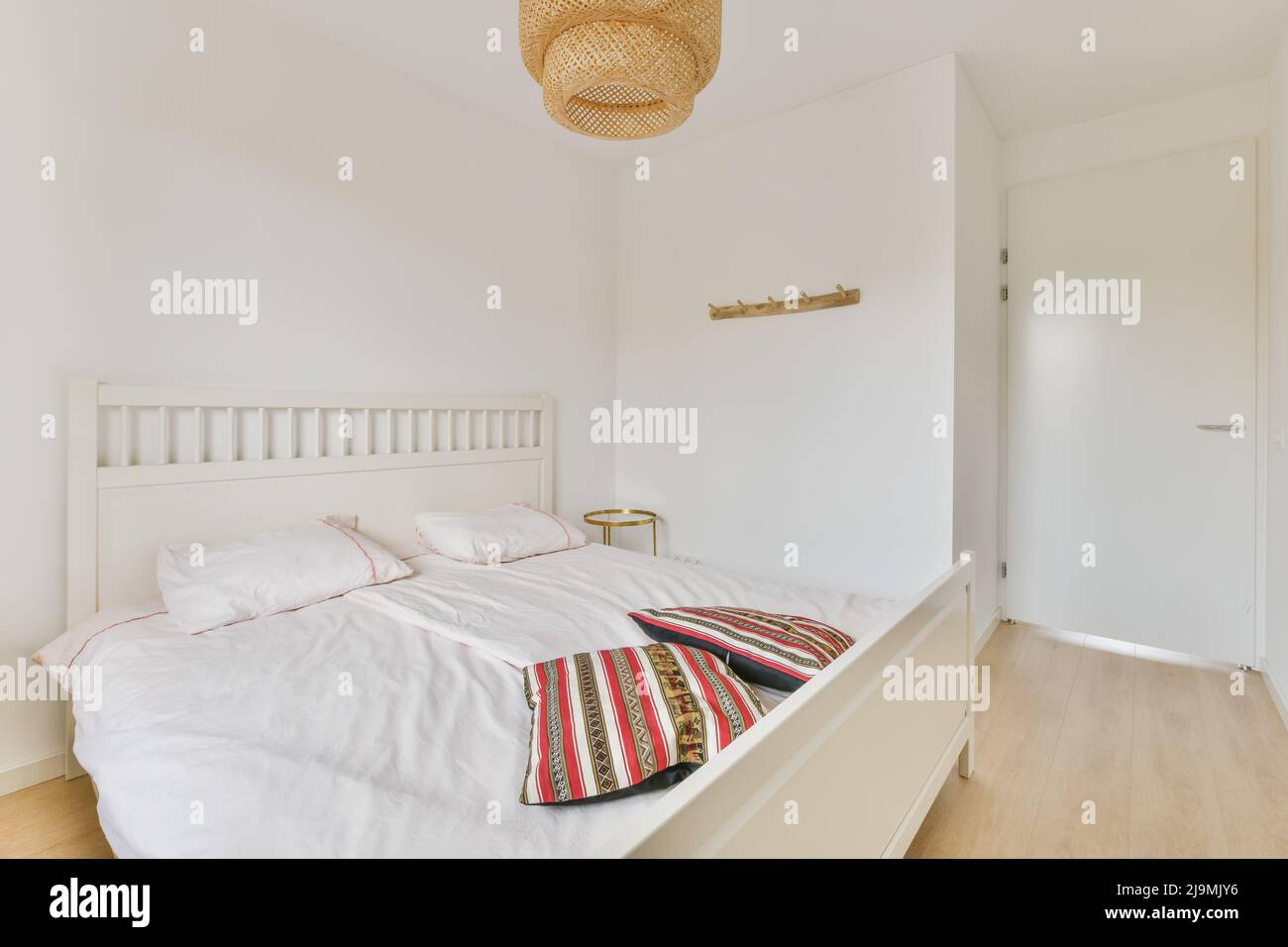 Comfortable bed with chrome glass bedside table located against window ...