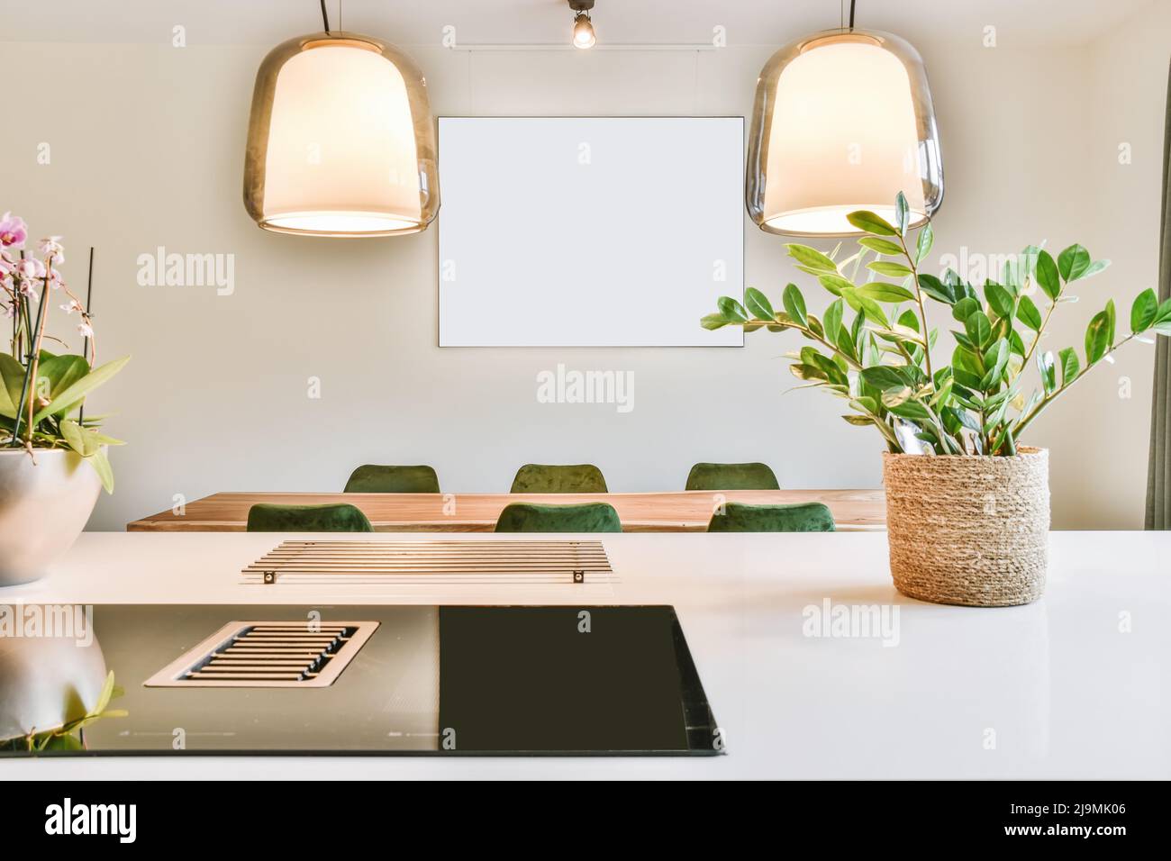 Blank picture hanging on wall over table with chairs behind lamps and ...