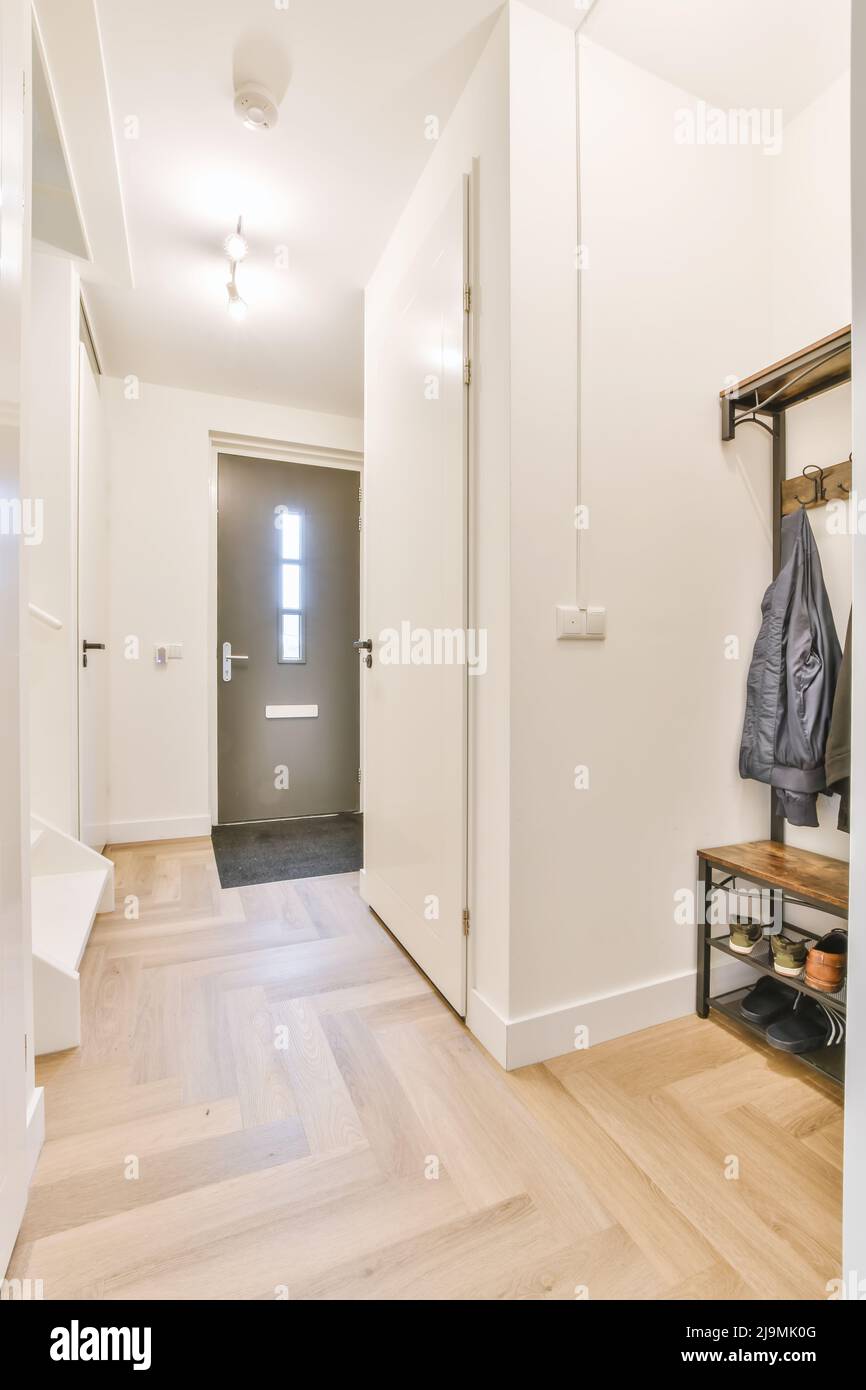 Interior of light contemporary hallway with shelf and exit door in ...