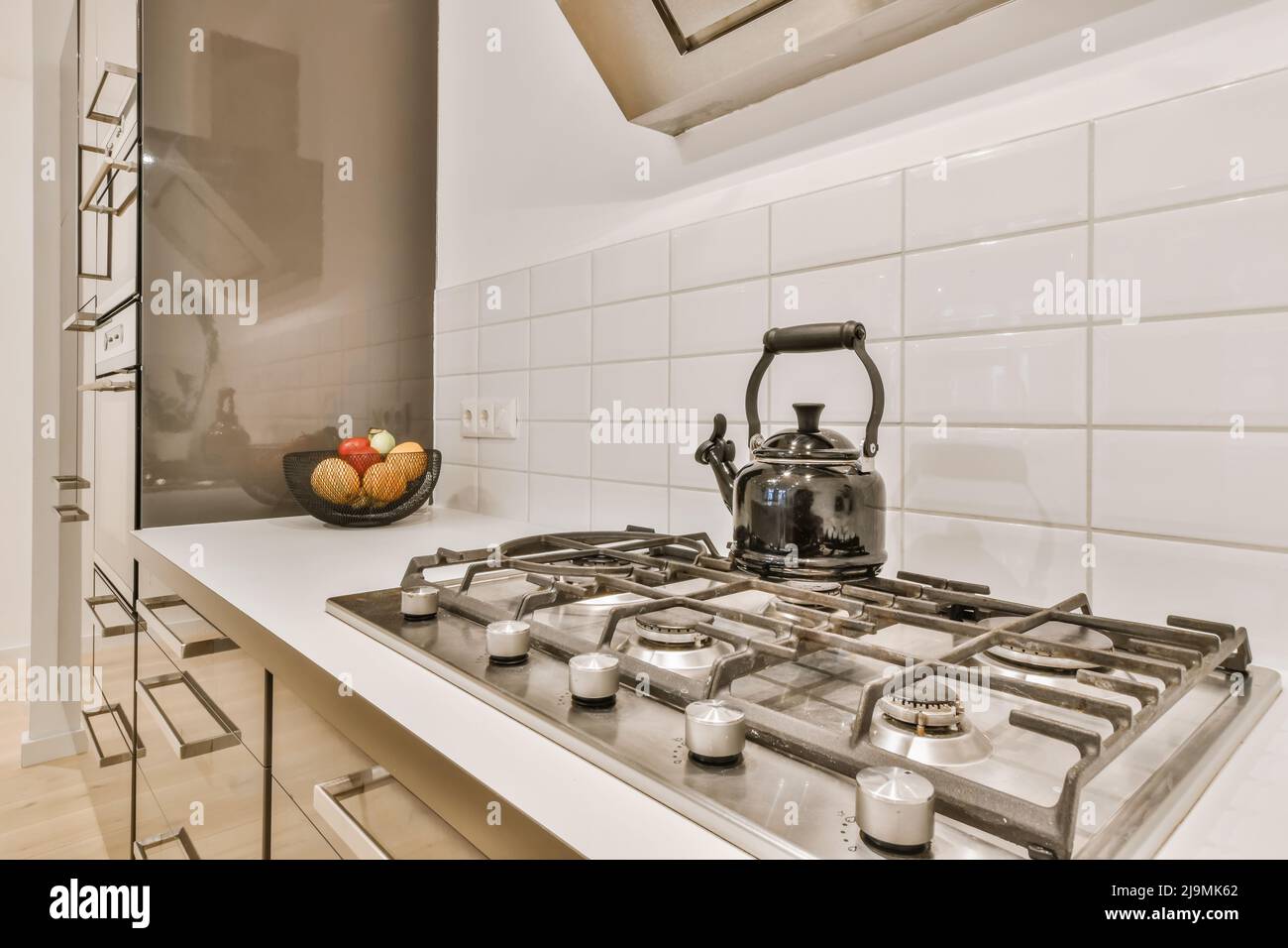 Gas cooker on wooden counter with flower in ceramic vase placed near ...