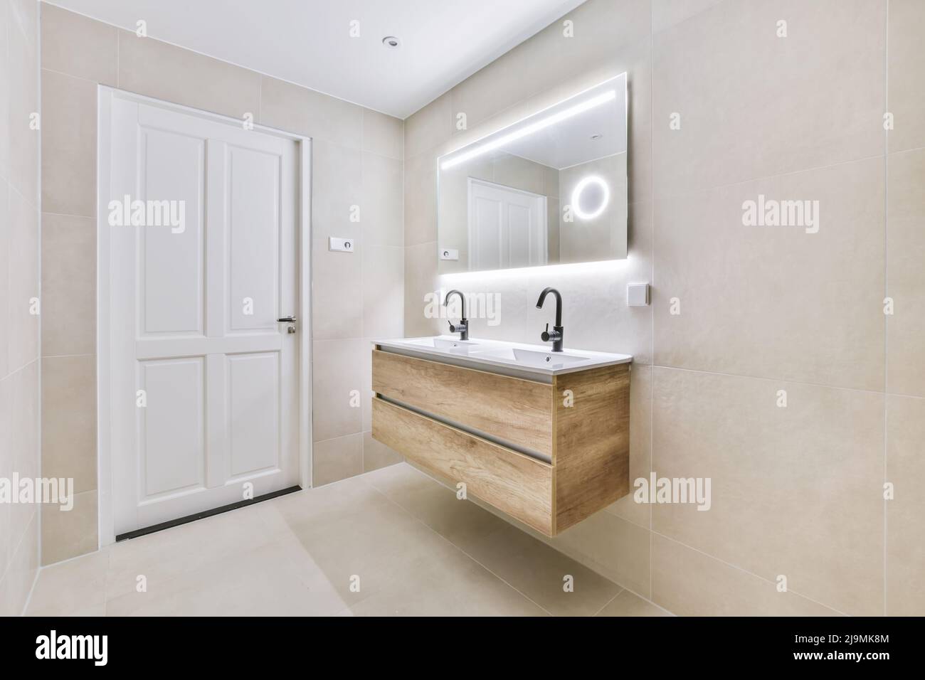 Interior of spacious bathroom with double ceramic sink and taps on ...
