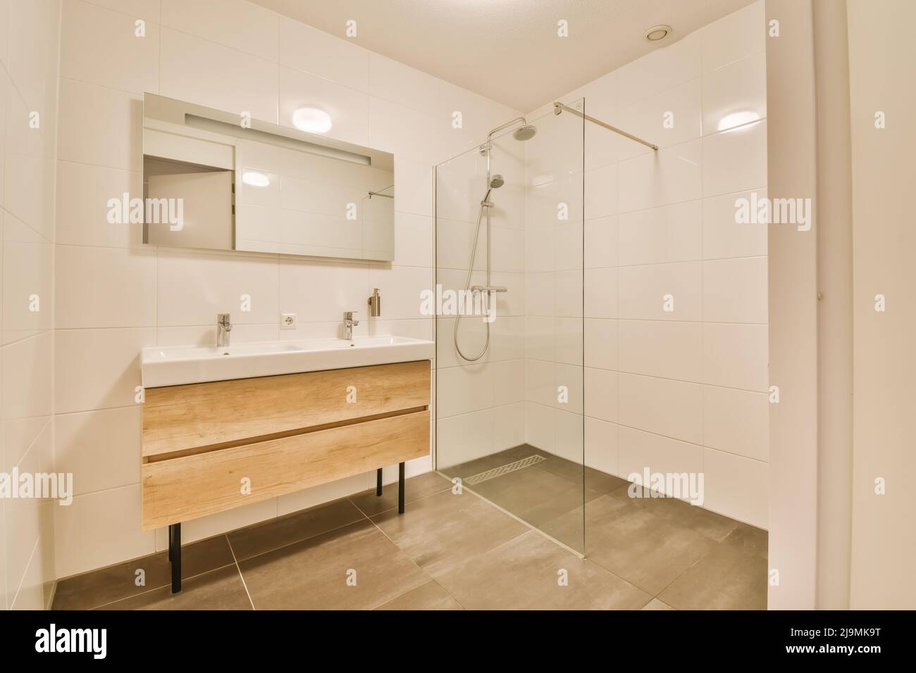 Interior of contemporary illuminated bathroom with glass shower cabin ...