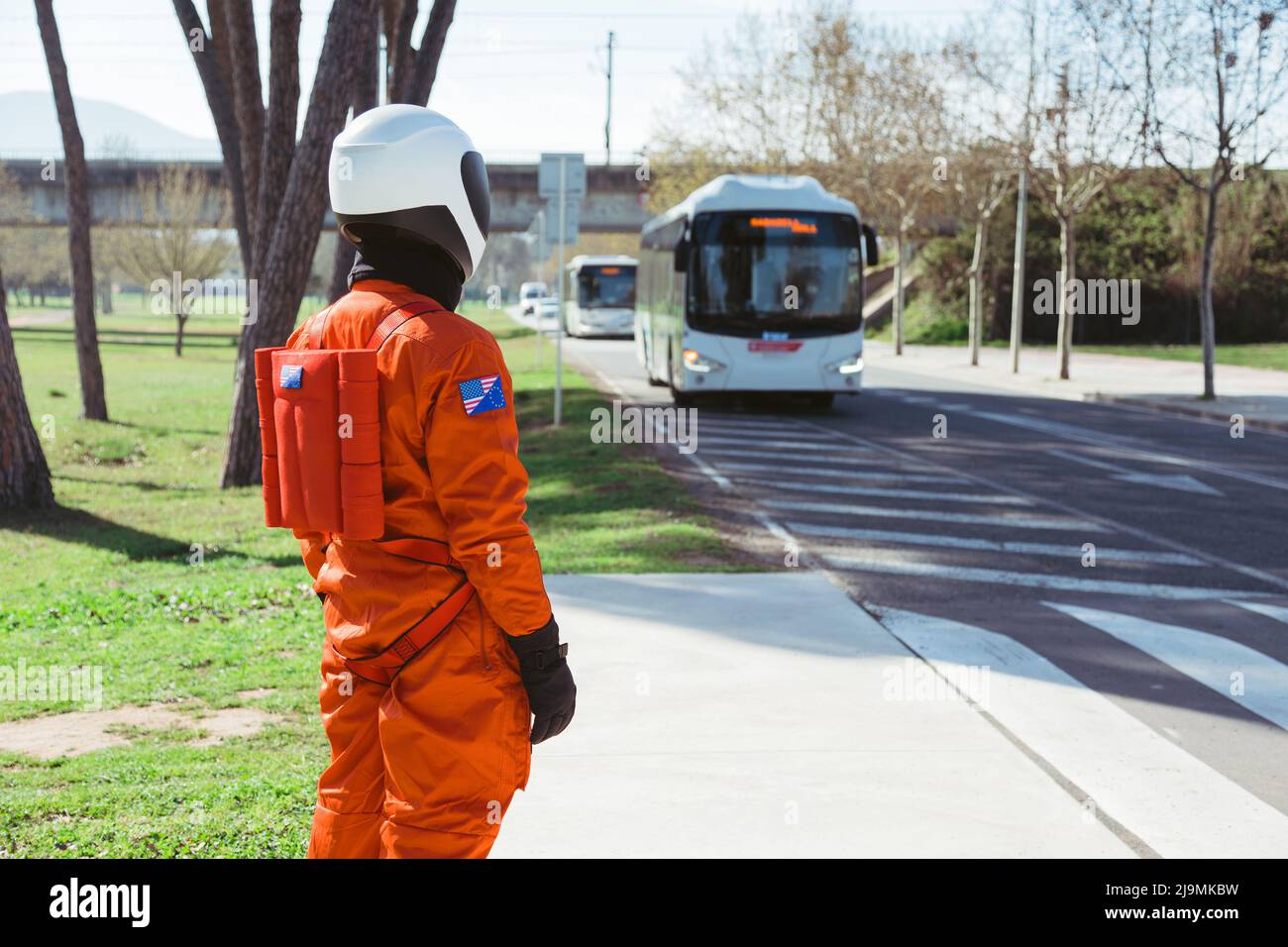 Side view of unrecognizable person in bright orange astronaut suit and ...