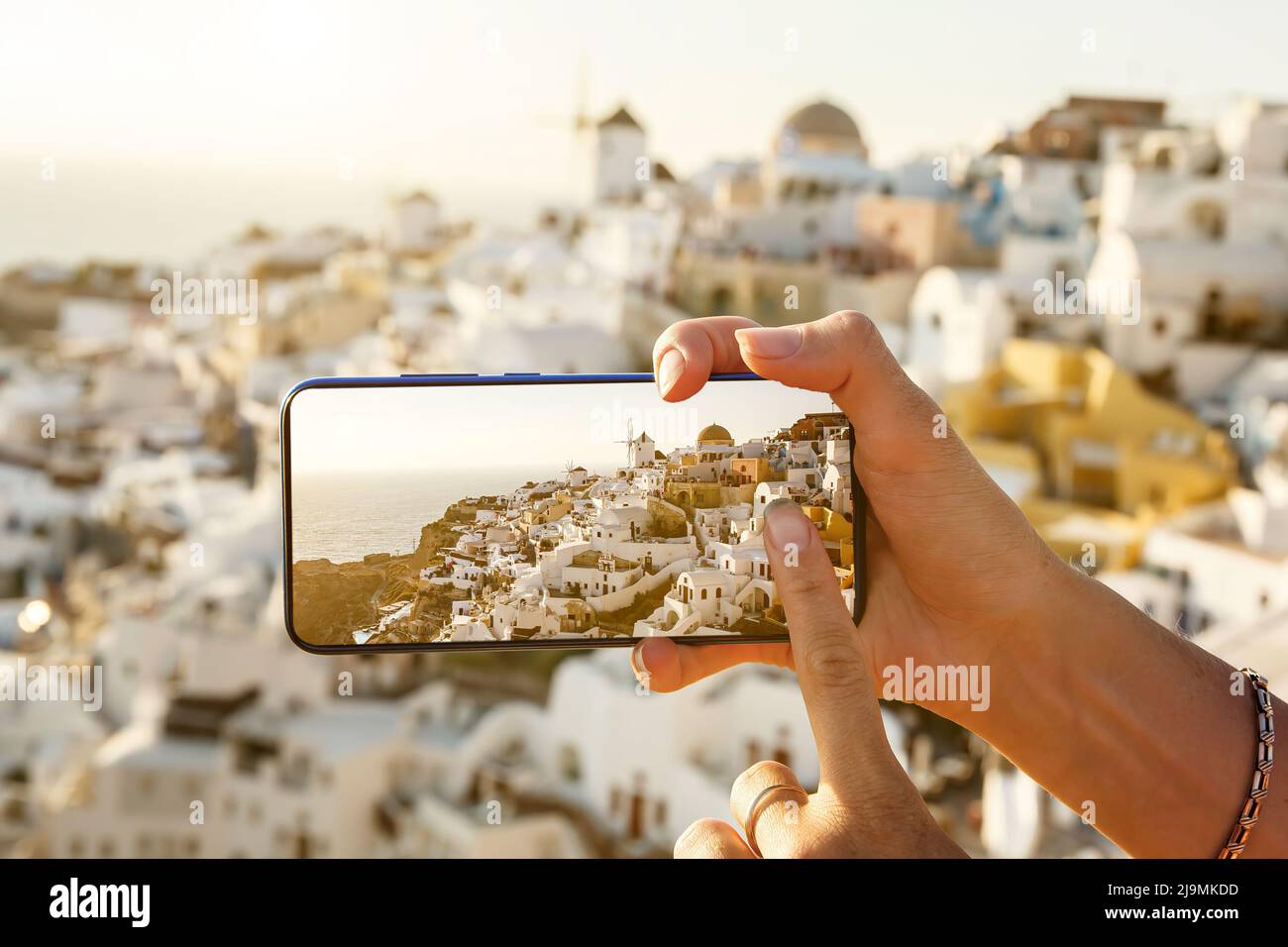 Making touristic photos via mobile phone. Smartphone using in Santorini ...