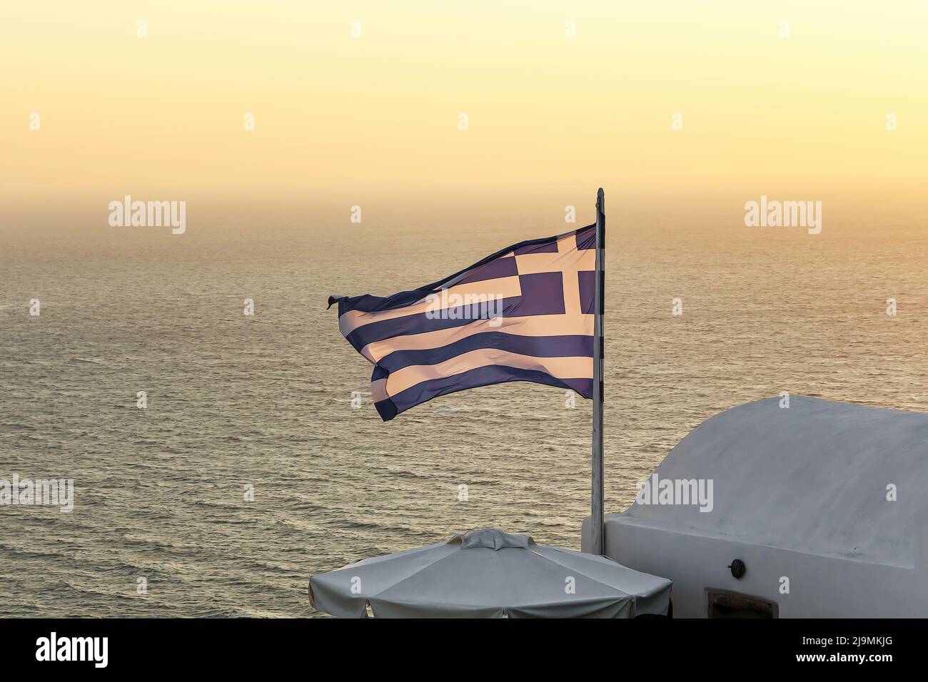 Greek flag near Aegean sea during sunset Stock Photo - Alamy