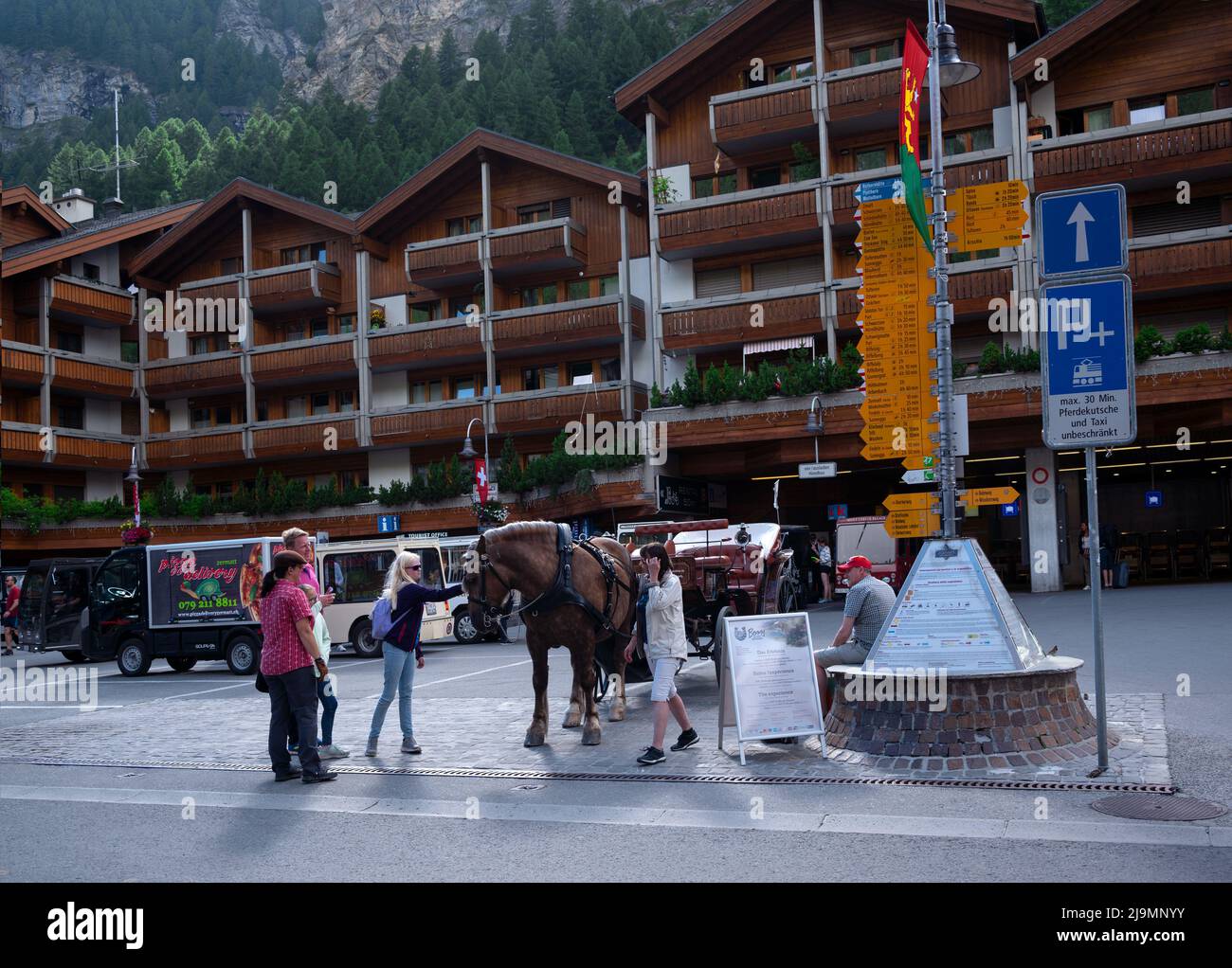 Horse coach carrying tourists on the main shopping street of Zermatt ...
