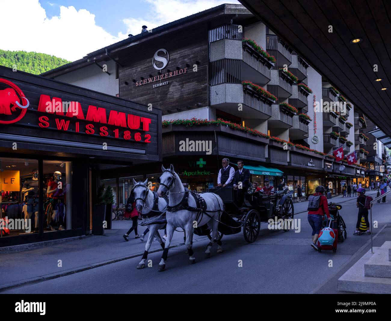 Horse coach carrying tourists on the main shopping street of Zermatt ...