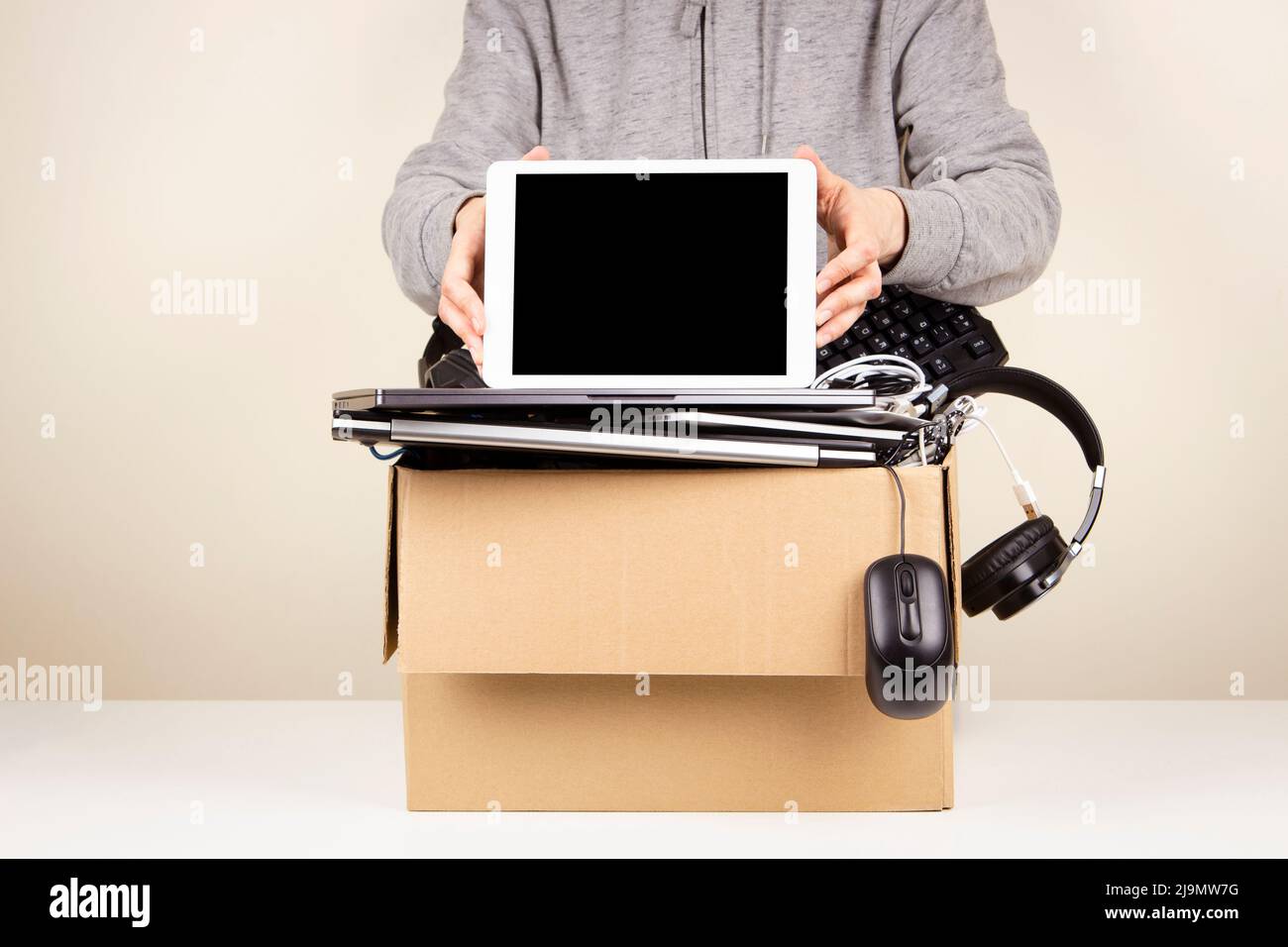 Woman hands holding digital tablet. Cardboard box full old used ...