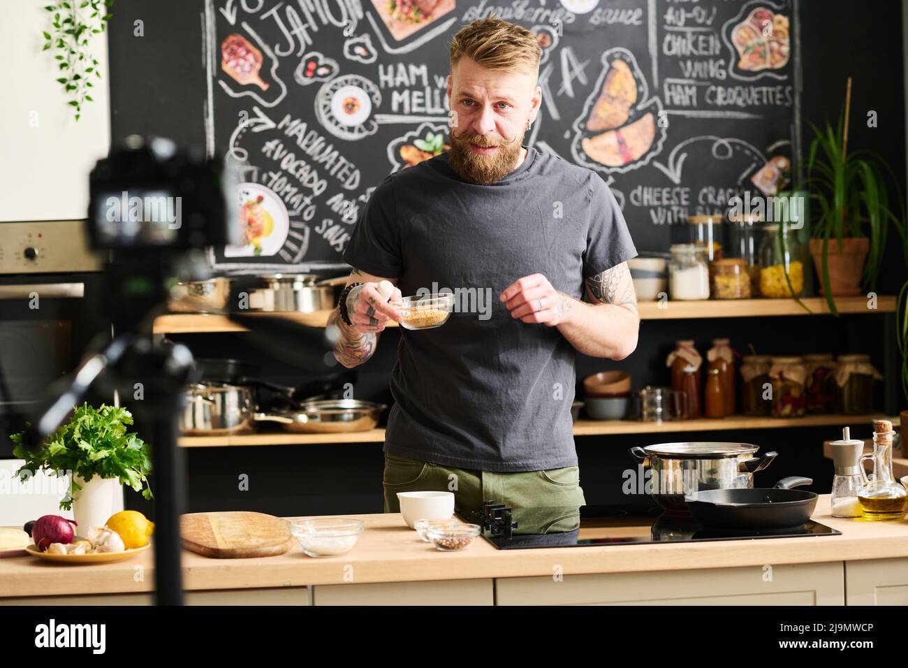 Modern male food blogger with beard on face holding glass bowl with ...
