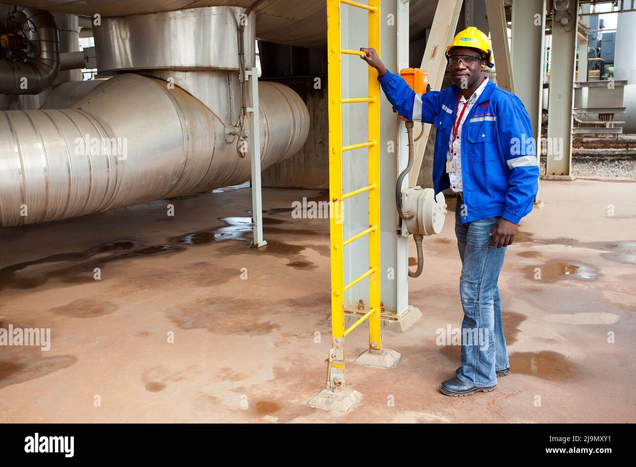 First Quantum employee in yellow hard hat holding a yellow ladder Stock ...