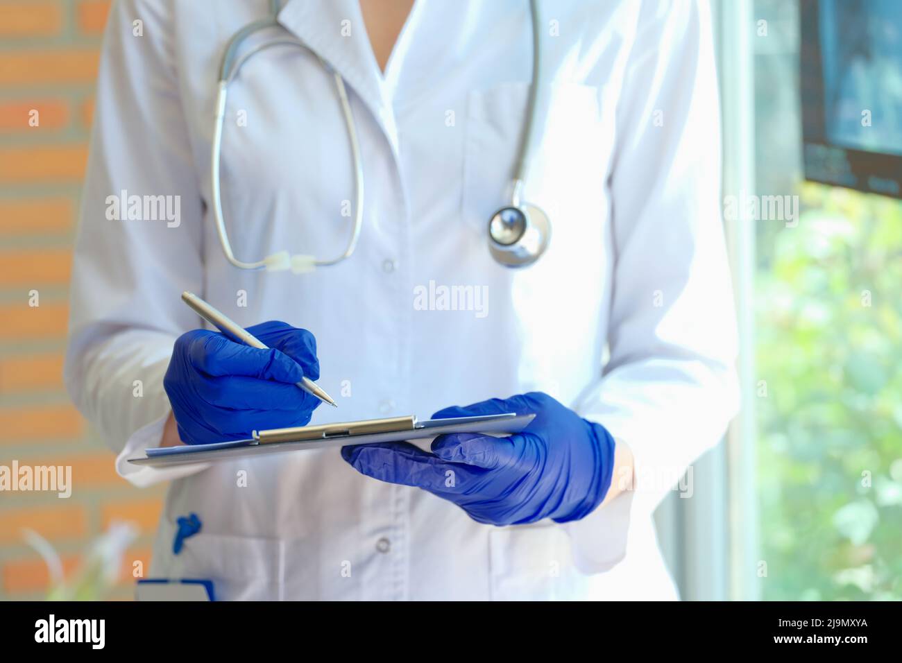 Doctor woman filling out medical form in medical documents Stock Photo ...