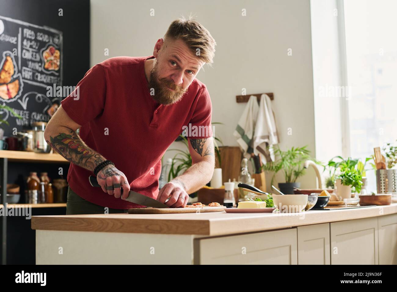 Confident Caucasian man with beard on face chopping and cutting ...