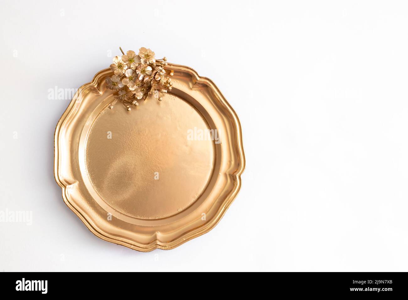round golden tray with metallic flower isolated on white background ...