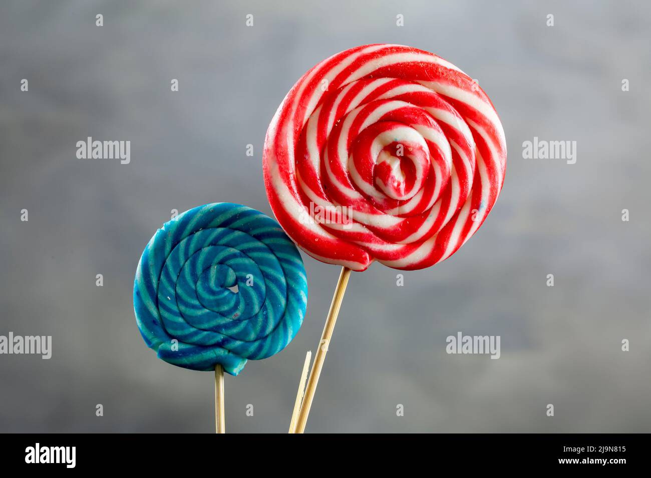 spiral lollipop in two colors: blue and red Stock Photo - Alamy