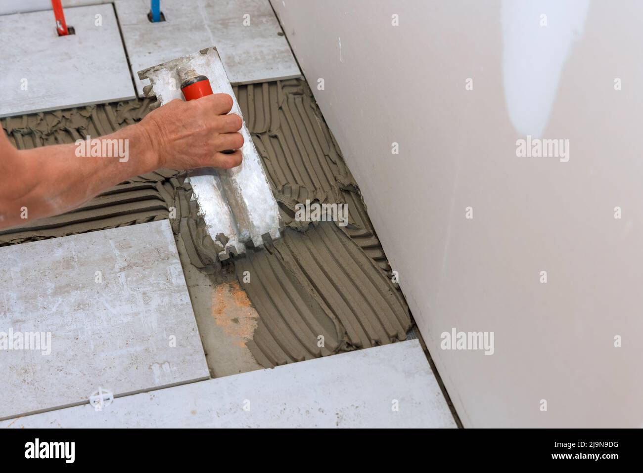 Bathroom renovation on the applying tile adhesive to the floor Stock ...