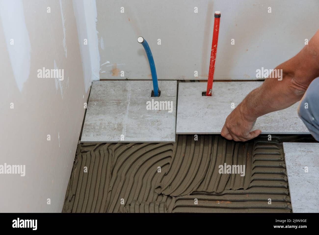 The process of hands of the worker are laying the ceramic tile Stock ...