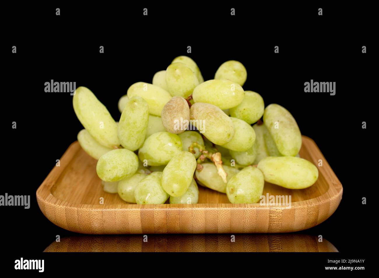 One bunch of white seedless grapes on a bamboo tray, close-up, isolated ...