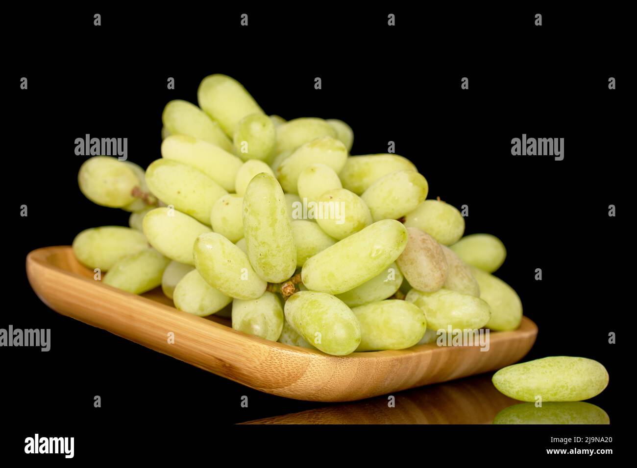 One bunch of white seedless grapes on a bamboo tray, close-up, isolated ...