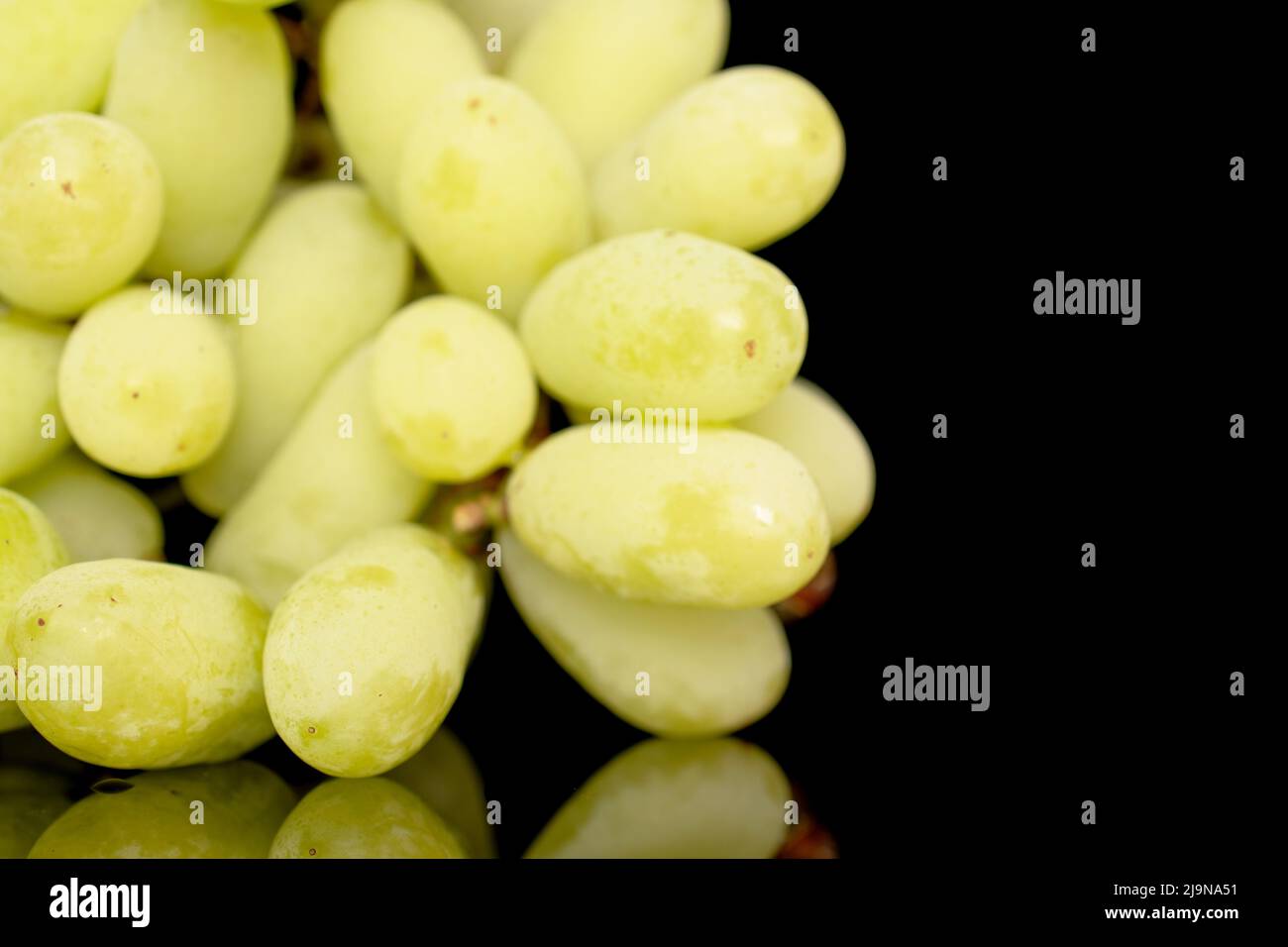 One bunch of white seedless grapes, close-up, isolated on a black ...