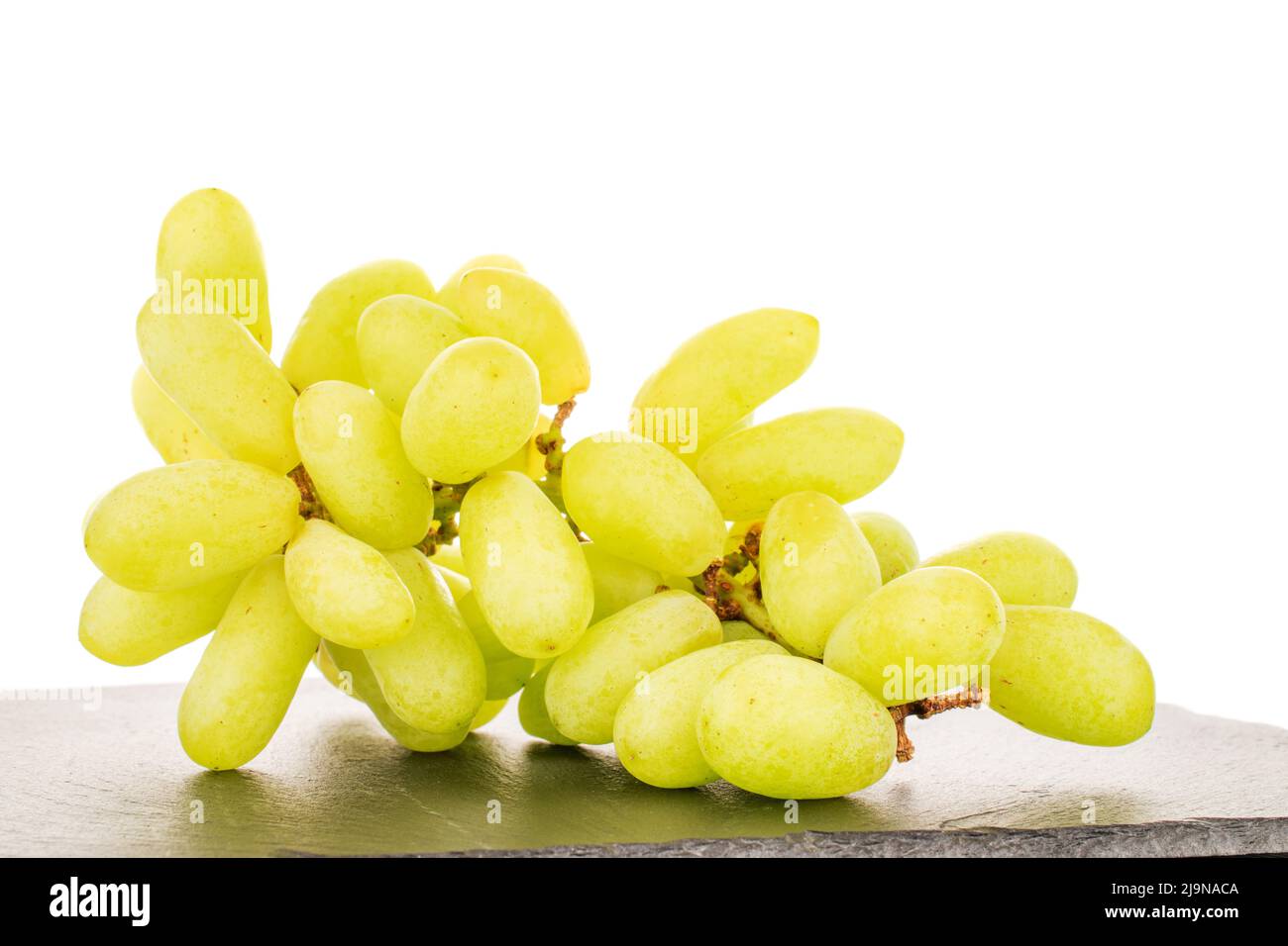 One bunch of white seedless grapes on a slate stone, close-up, isolated ...