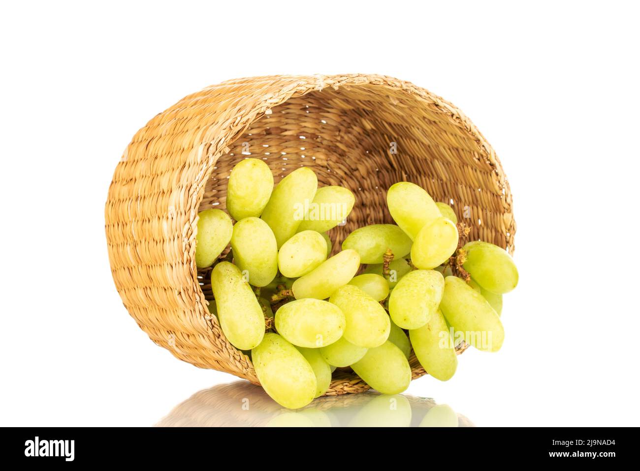 One bunch of white seedless grapes in a straw basket, close-up isolated ...