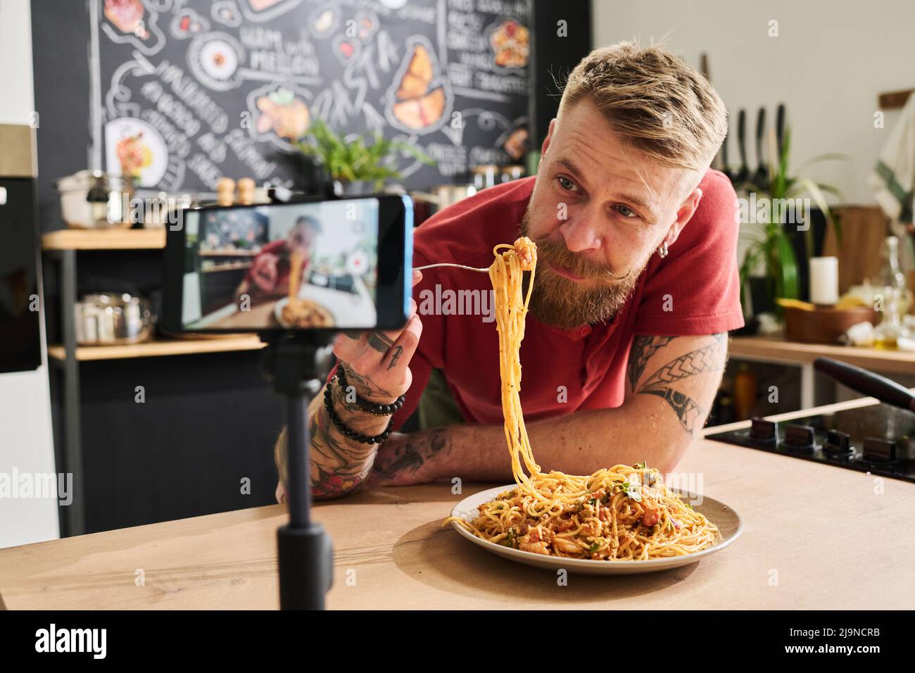 Food blogger eating homemade pasta while filming recipe and mukbang ...