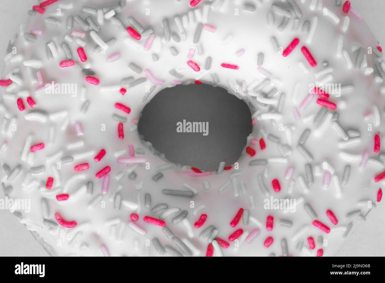 Flat-lay image of ring donut with white glaze and hundreds and ...