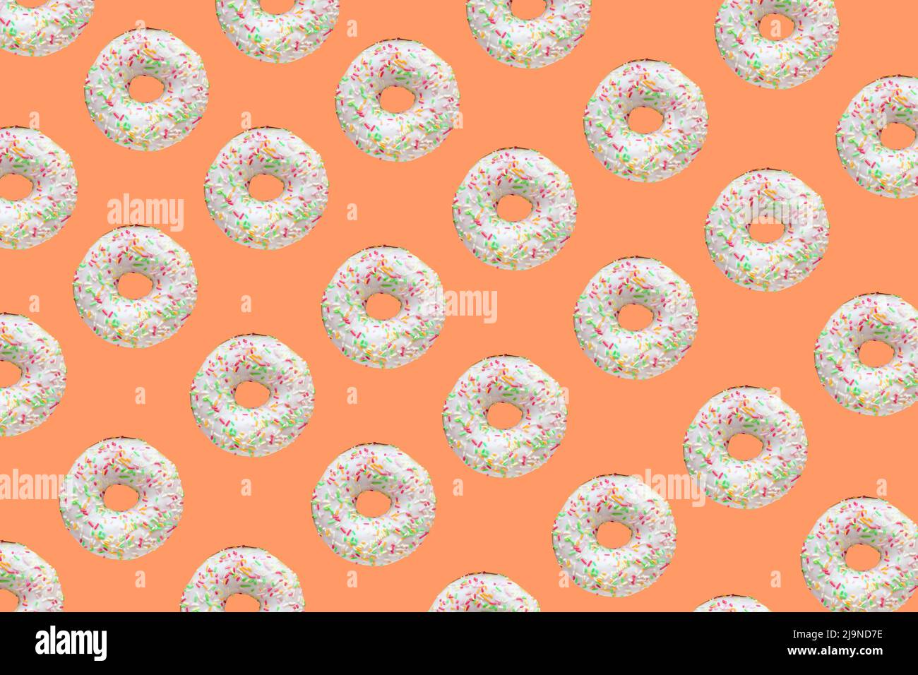 Pattern made of ring donuts with white glaze and clourful hundreds and ...