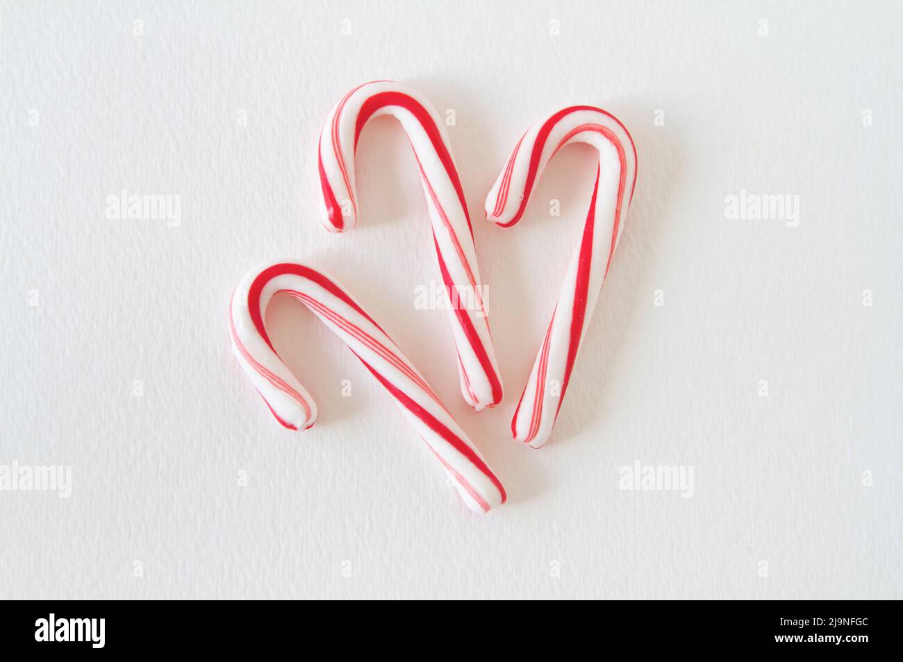 Three candy canes on bright white background Stock Photo - Alamy