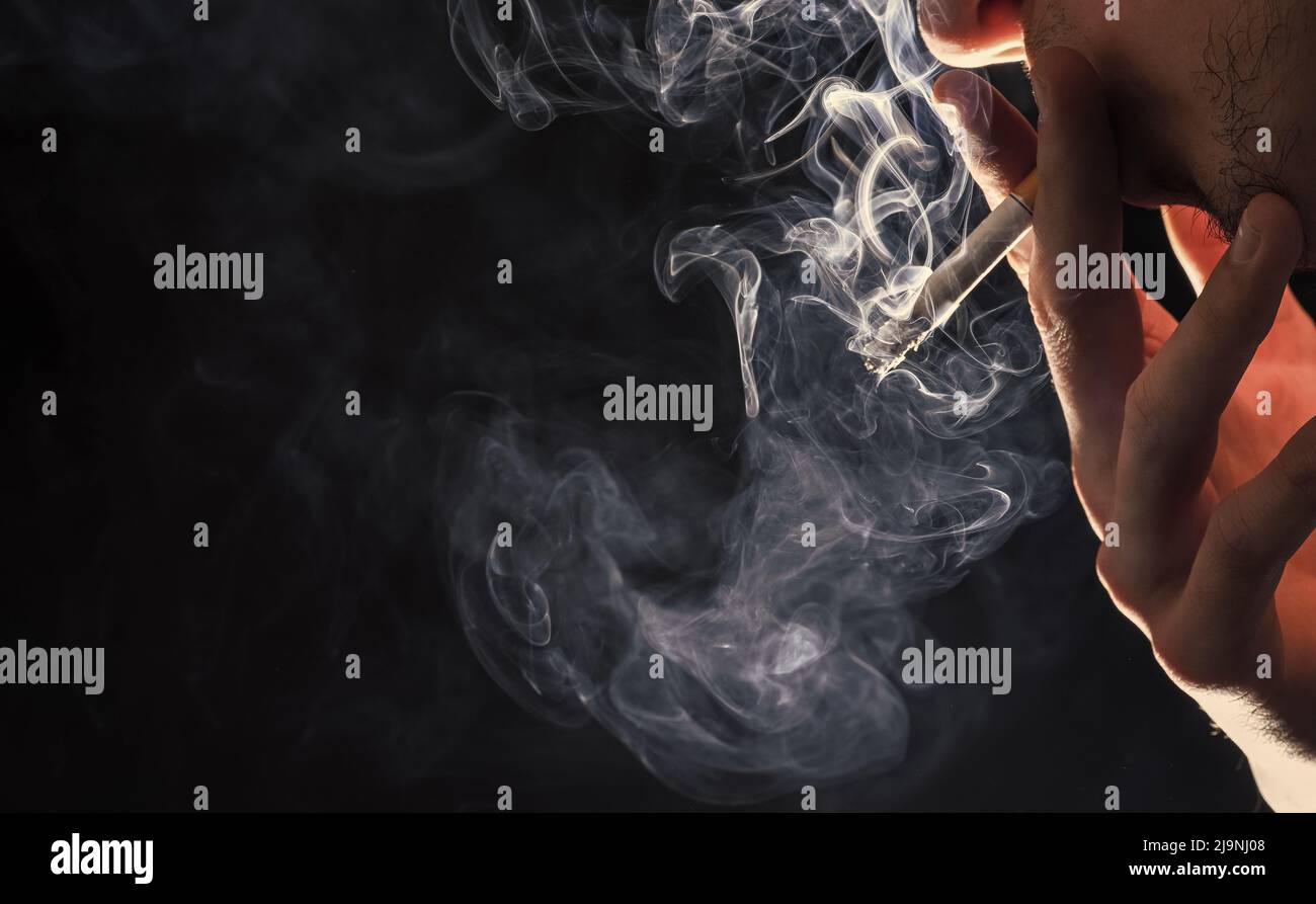 Smoke and choke. Cigarette smoke dark background. Steaming cigarette in ...