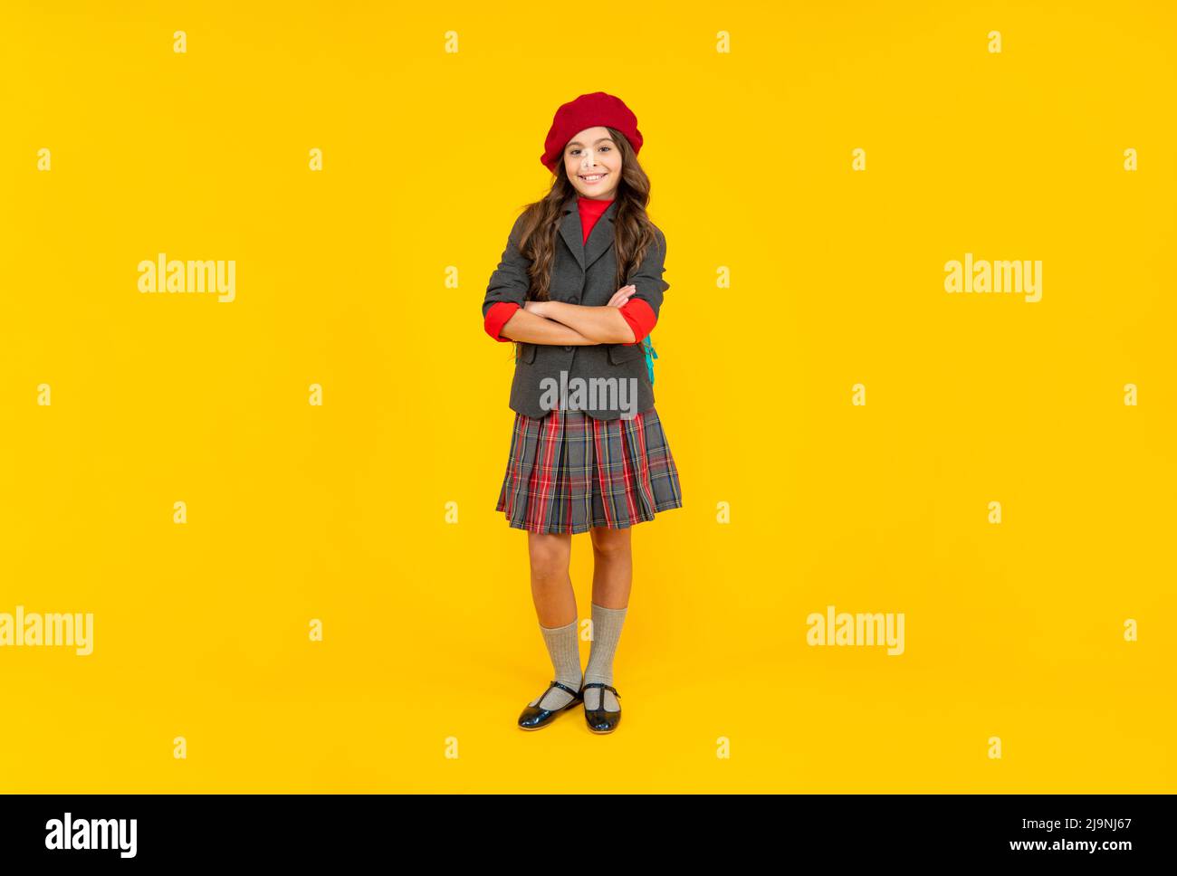 happy child in school uniform and beret full length on yellow ...