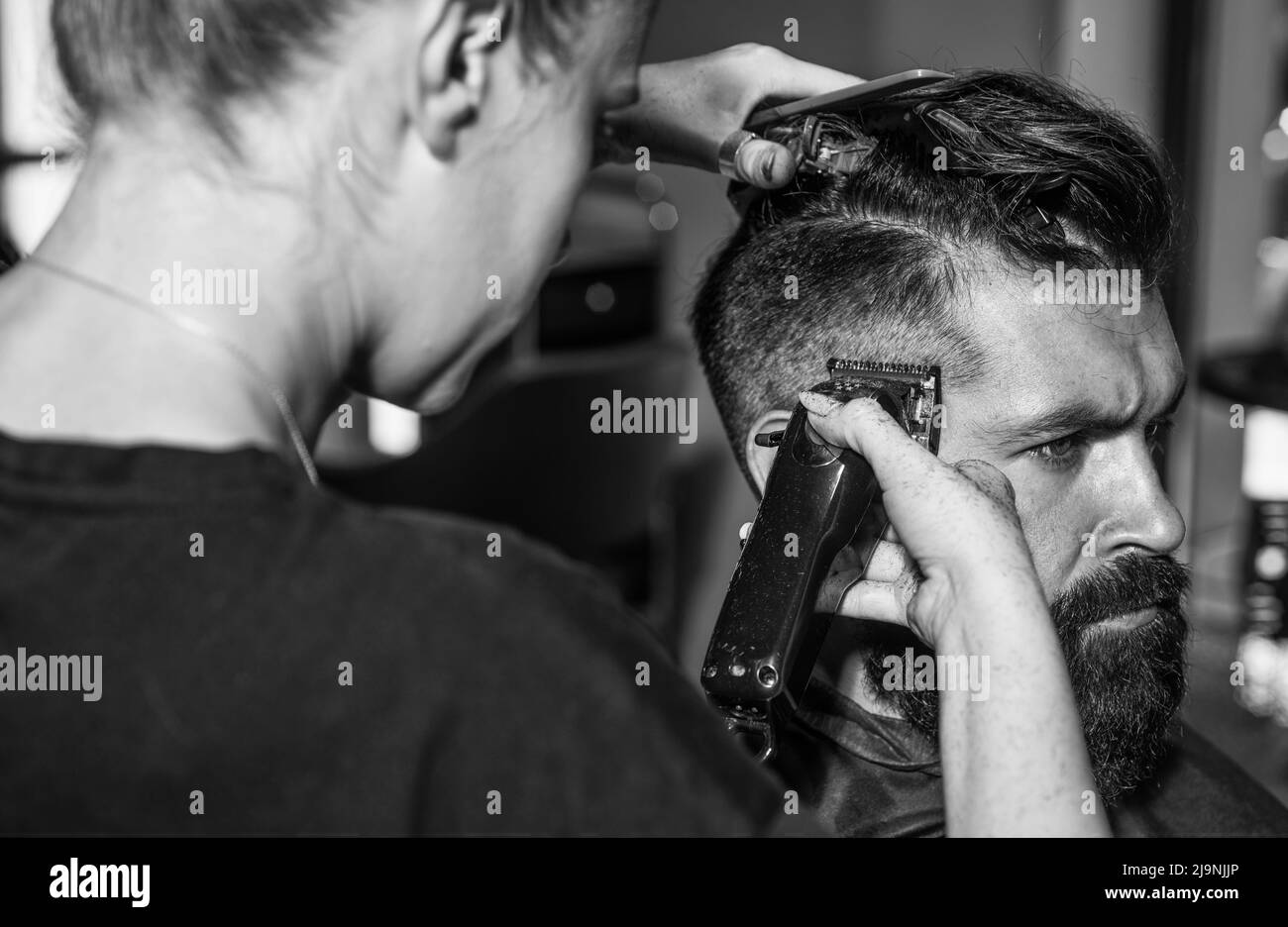 Close-up of barber styling beard to male in barbershop, Personal ...