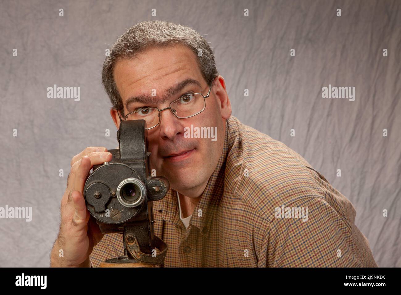 Studio shot of a middle aged camernman director shooting a movie on a ...
