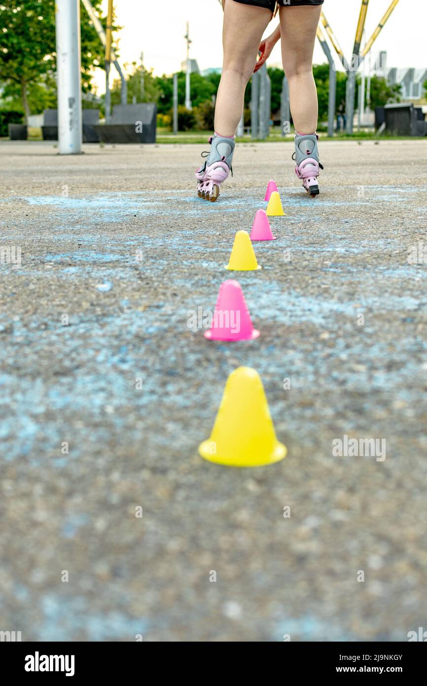 girl skating with pink and yellow cones Stock Photo - Alamy