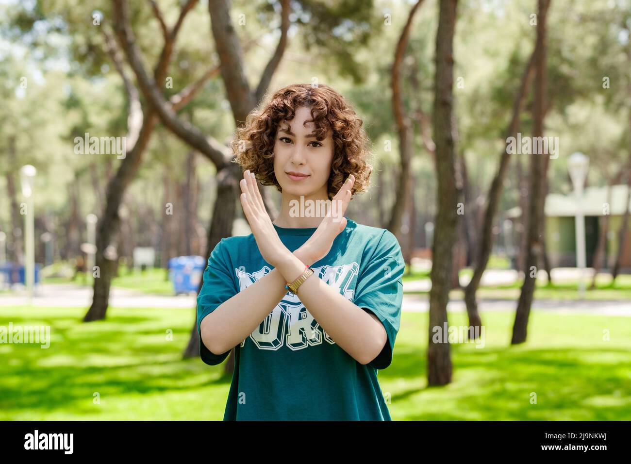 Young Redhead Serious Woman Wearing Green T Shirt Standing On City Park