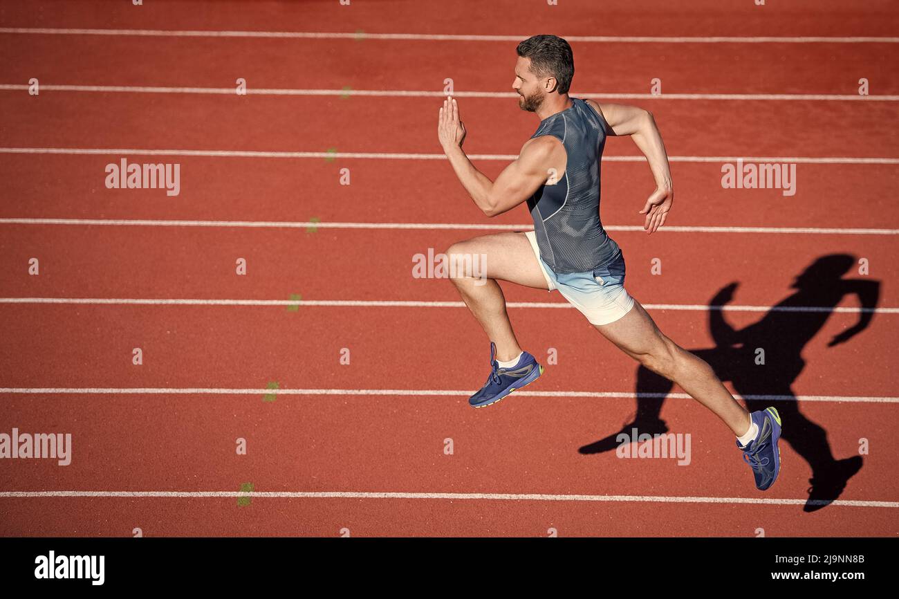 energetic athletic muscular man runner running on racetrack at outdoor ...