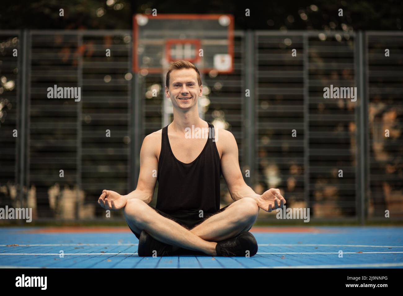 Relaxed man doing exercise and meditation yoga on gym outdoor. Fitness ...