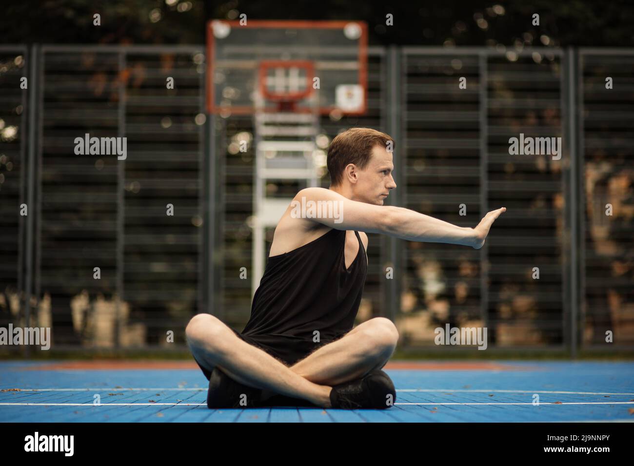 Fitness man doing exercise in outdoor gym. Man warm up by stretching ...