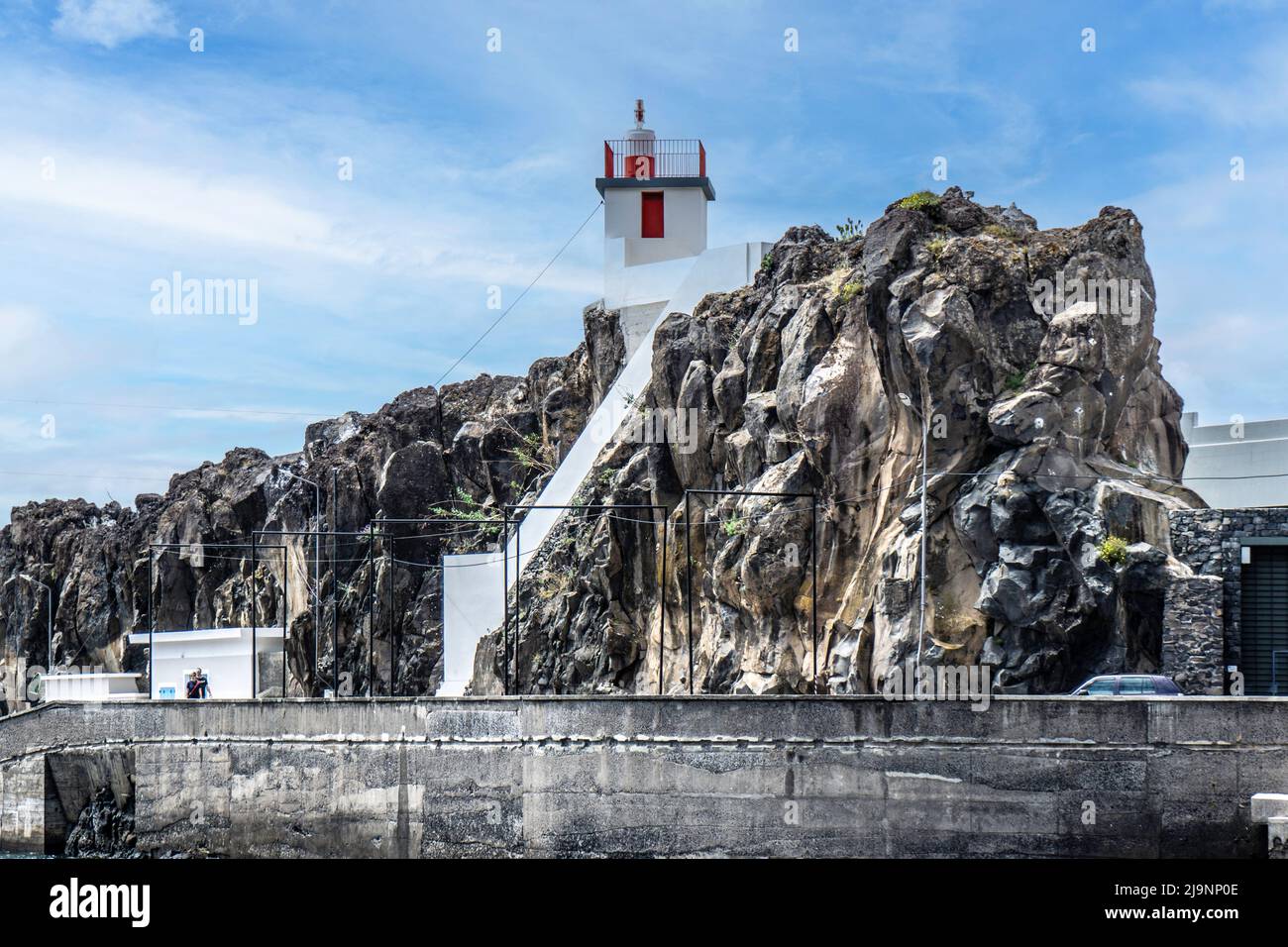 The lighthouse overlooking the harbour area of Camara de Lobos in ...